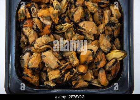 Plastic container with delicious mussels in tomato sauce on wooden ...