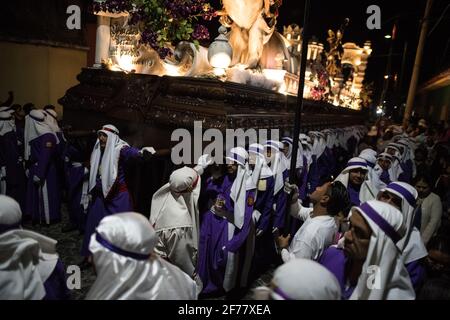 Cucuruchos in purple robes process solemnly through the streets of ...