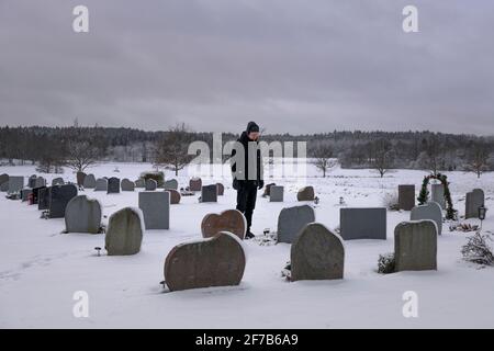 Man standing over grave at cemetery Stock Photo - Alamy