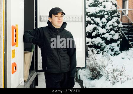 Courier standing near lorry Stock Photo - Alamy
