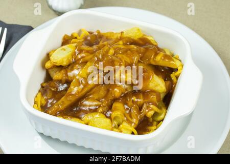 poutine in a dish on a table Stock Photo - Alamy