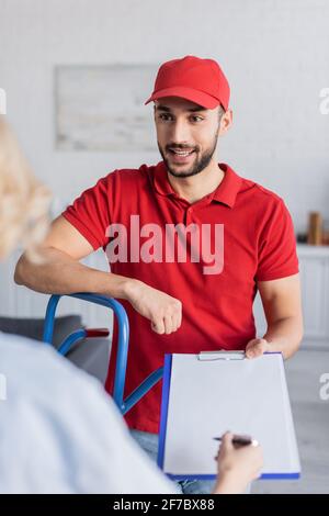 Young arab man holding empty frame doing ok sign with fingers, smiling ...