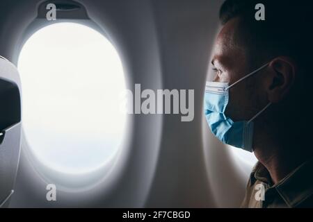 New normal travel during COVID-19 restrictions, flat lay on blue. Hand ...