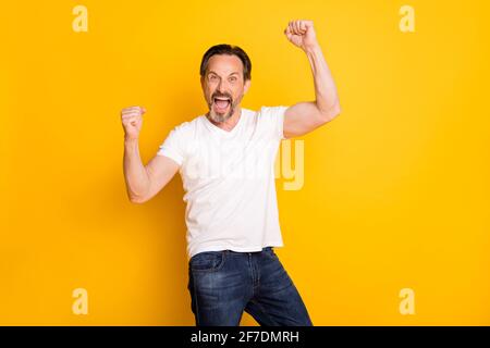 Photo of victorious happy cheerful mature man look empty space raise ...