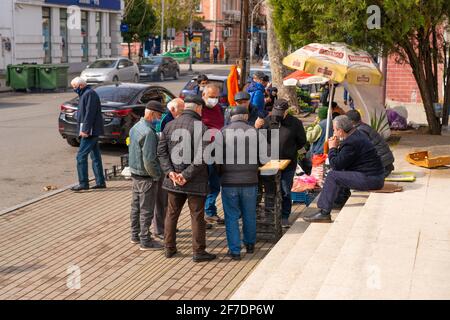 Batumi, Georgia - March 15, 2021: Woman's hand in a red jacket puts a ...