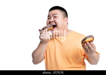 Young man eating donut Stock Photo - Alamy