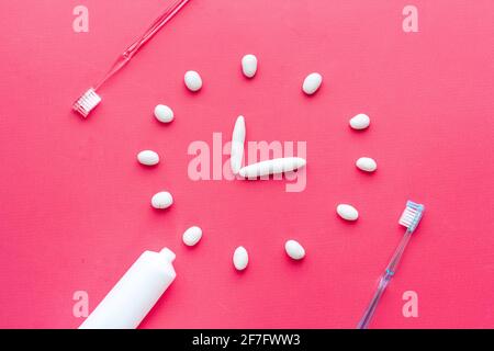 Morning routine concept. Clock made of toothpaste with toothbrushes ...