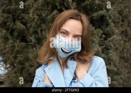 Lady in light blue coat walks down the entrance path towards the ...