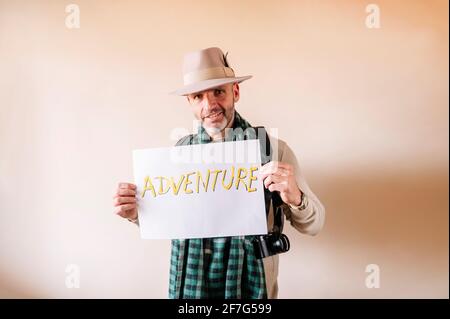 Man holding ADVENTURE sign with hat and backpack Stock Photo - Alamy