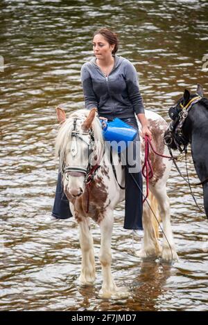 young gypsy traveller woman on horse in river in Appleby Horse fair ...
