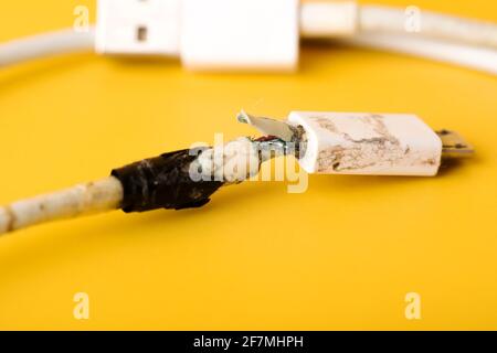 Torn cord for charging a mobile phone type si on a white background ...