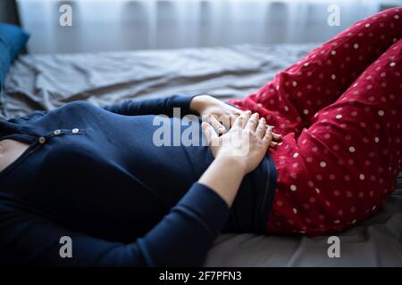 Pregnant woman with stomach ache holds her tummy in pain. Abdominal ...