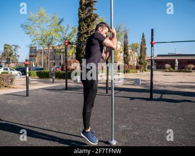 Young Caucasian man doing pole exercises in a park in Toledo, Spain on ...