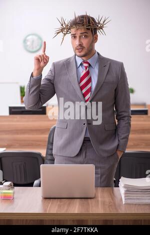 Young businessman employee wearing prickly wreath on head Stock Photo ...
