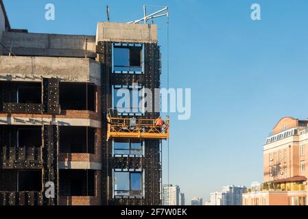 Professional workers use a suspended cradle or steeplejack to access ...