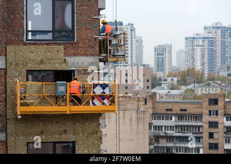 Professional workers use a suspended cradle or steeplejack to access ...