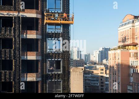 Professional workers use a suspended cradle or steeplejack to access ...