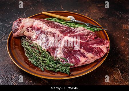 Raw hanging tender or ongle beef meat steak on rustic plate with herbs ...