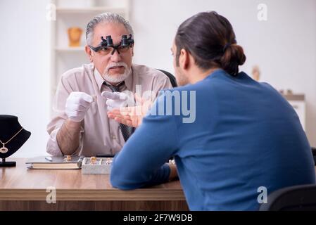Young man visiting old jeweler Stock Photo - Alamy