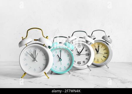 Different alarm clocks on light background Stock Photo - Alamy