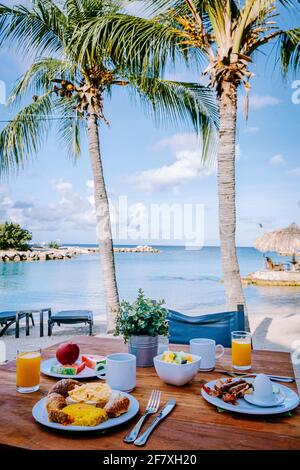 breakfast on a table by the beach looking out over the ocean, Caribbean ...
