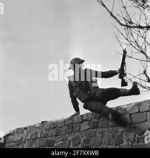 An armed soldier jumps over a wall Stock Photo - Alamy