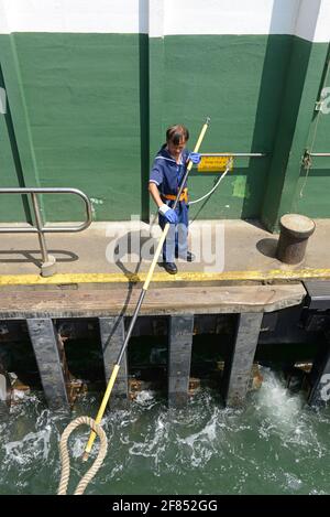 A ferry worker prepares to dock at the Star Ferry Pier in Hong Kong ...