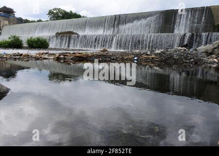 a two-story waterfall with little pebbles on the shore Stock Photo - Alamy