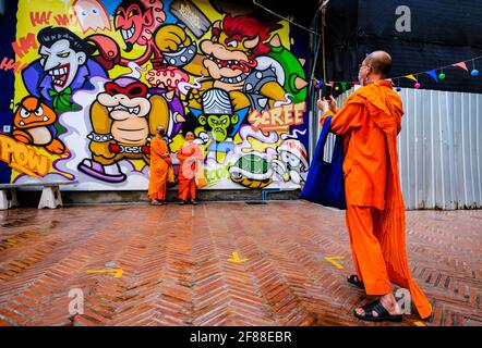 Two monks in front of mural of the Reamker poem showing war painted in ...