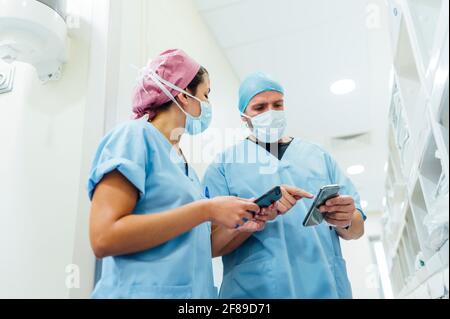 Doctors using cell phones in the hospital corridor. Medical concept ...