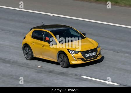 2020 yellow Peugeot 208 GT EV driving on the M6 motorway near Preston ...