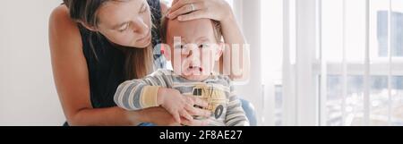 Mother hugging pacifying sad upset crying toddler girl. Family young ...