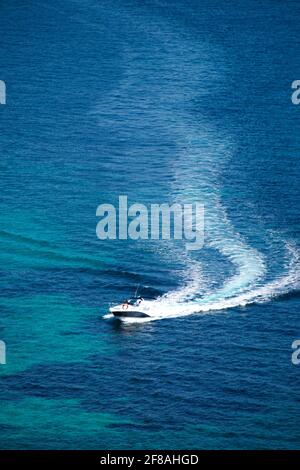 Boat quickly floating on the water surface and leaving a trail on the ...