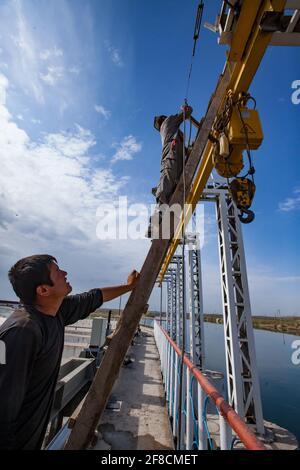 Kazakhstan, Shardara water storage dam. Group of Uzbek workers mixing ...