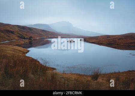Picturesque view of Loch Fada lake near hills covered with grass under ...