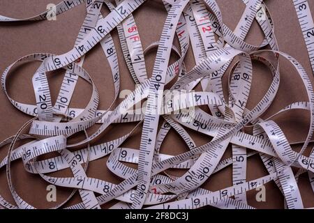 Tape measure rolled out randomly Stock Photo - Alamy