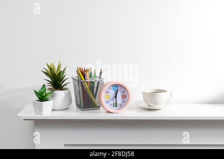 Notebook, holder with pencils, cup and cactus on wooden background ...