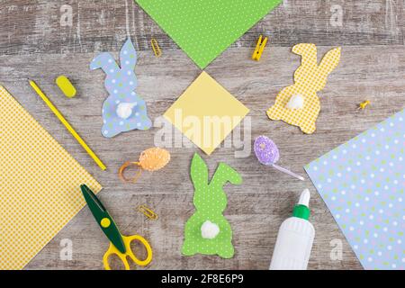 Colorful Easter paper bunnys, rabbits with a tail on wooden table. DIY ...