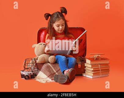 Cute little adventurer with books and toy airplane on light blue ...