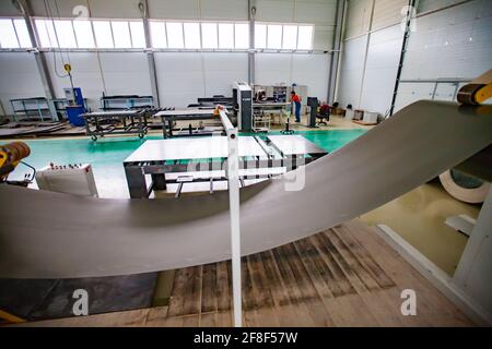 Aktau, Kazakhstan. CNC laser cutting machine and two workers with ...