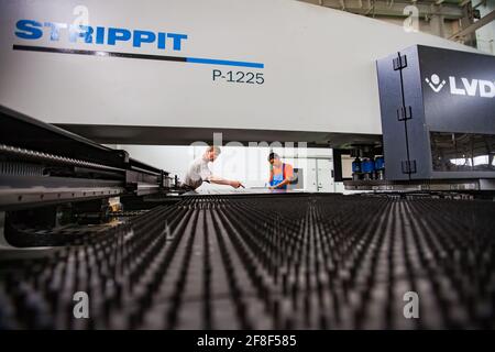 Aktau, Kazakhstan. CNC laser cutting machine and two workers with ...