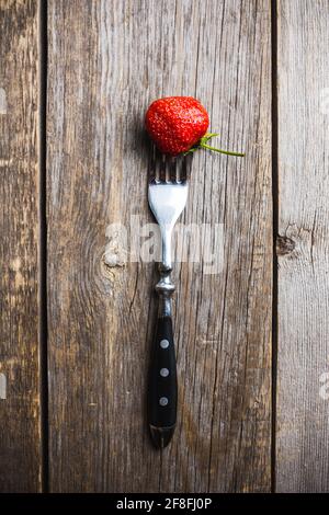 Ripe and juicy bitten strawberry on the fork. Selective focus. Shallow ...