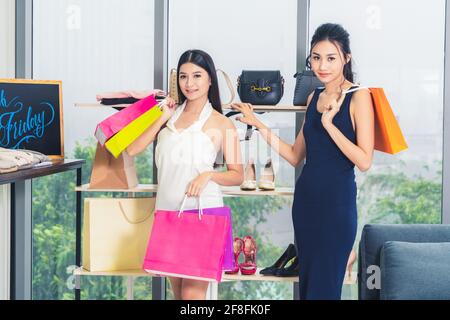 two happy asian shopaholic women with colorful shopping bags at ...