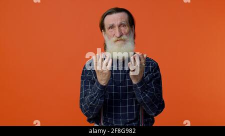 Hopeful sad man making a wish, cross fingers for good luck and sulking ...