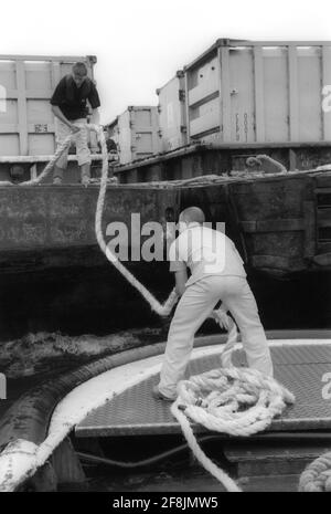 Lightermen of the River Thames using ropes to secure the barges for ...