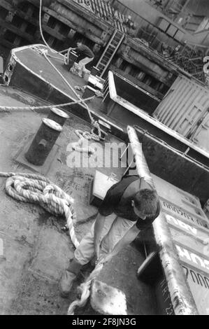 Lightermen of the River Thames using ropes to secure the barges for ...