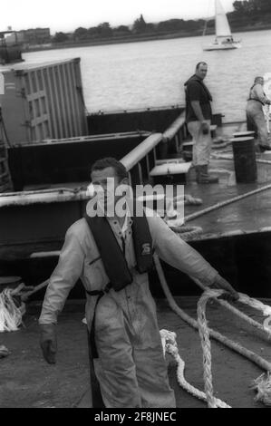 Lightermen of the River Thames working on the barges. working jumping ...