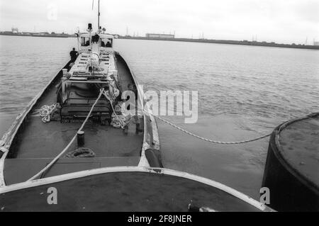Lightermen of the River Thames using ropes to secure the barges for ...