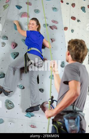 young woman scaling indoor climbing wall Stock Photo - Alamy