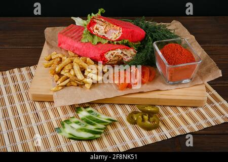 Fresh hot fragrant shawarma cut lies on a wooden board with vegetables ...